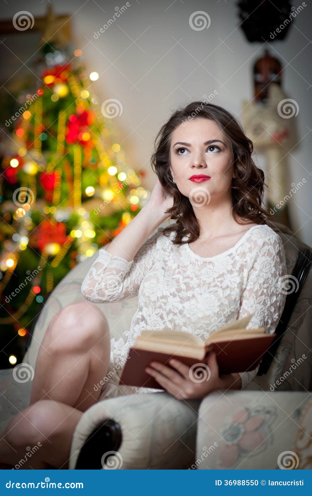 Beautiful Sexy Woman With Xmas Tree In Background Reading A Book