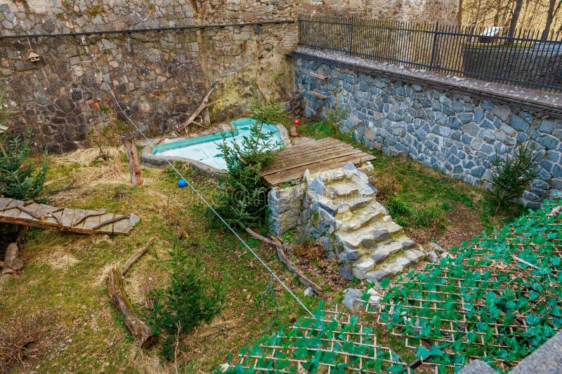 Abandoned Animal Enclosure with Empty Pool and Stone Walls in Overgrown ...