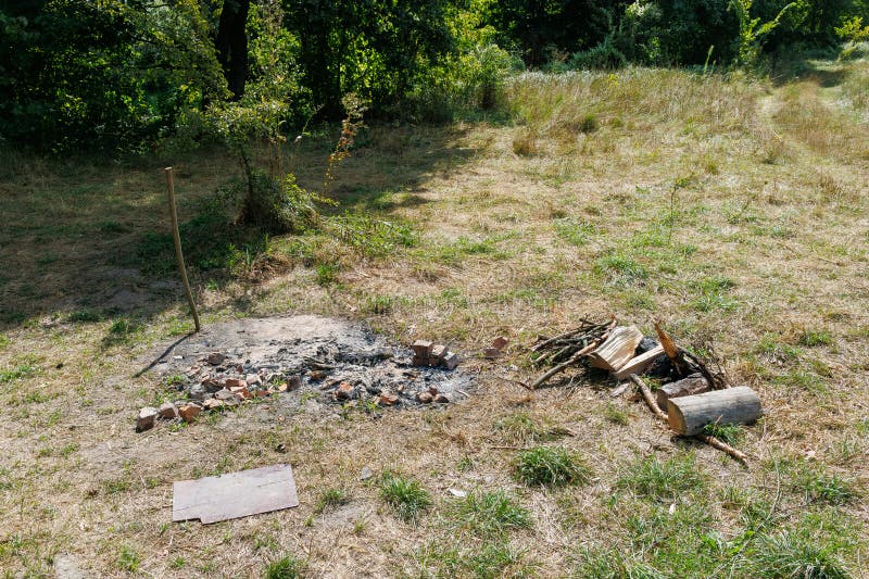 Abandoned Campfire Site with Ashes, Logs and Scattered Bricks in a ...