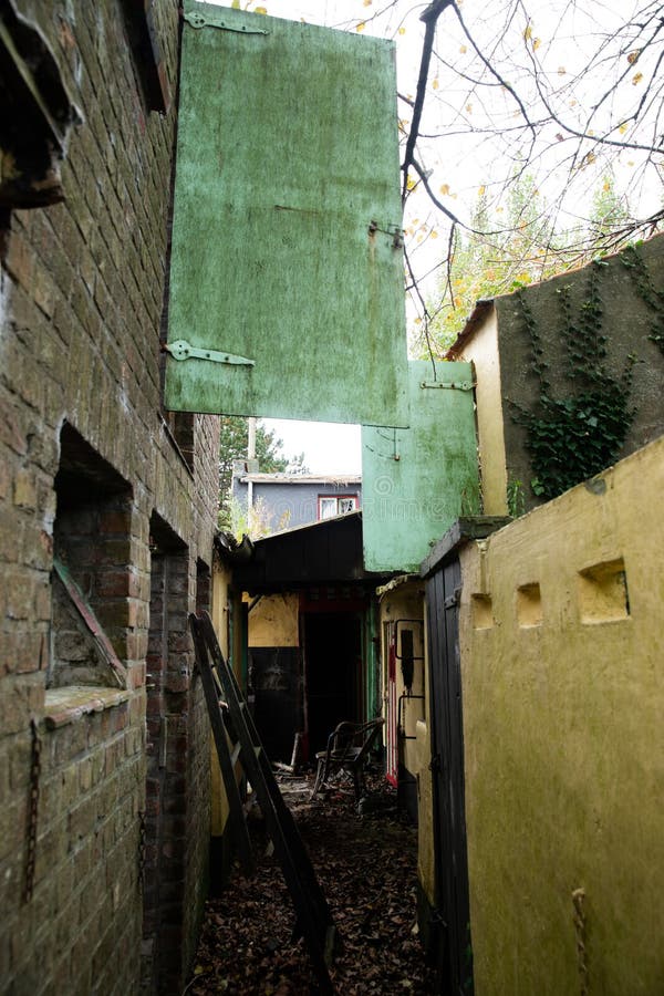 Abandoned Courtyard with Weathered Green Gate and Overgrown Pathway ...