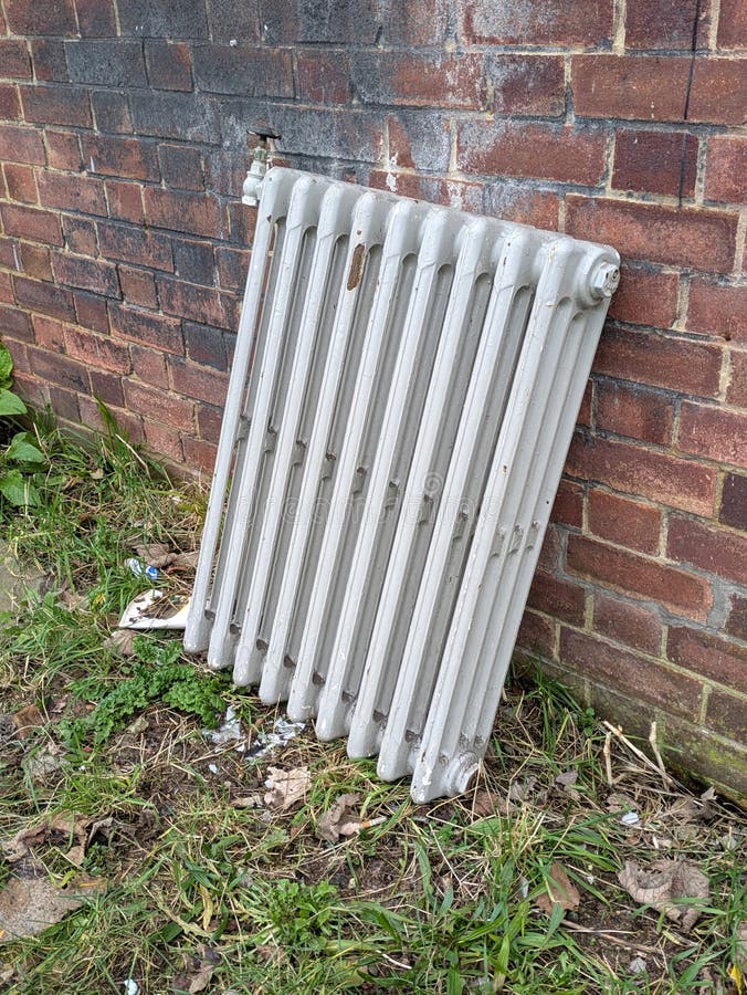 An Abandoned Dumped Radiator Heater Left Against a Wall Stock Photo ...