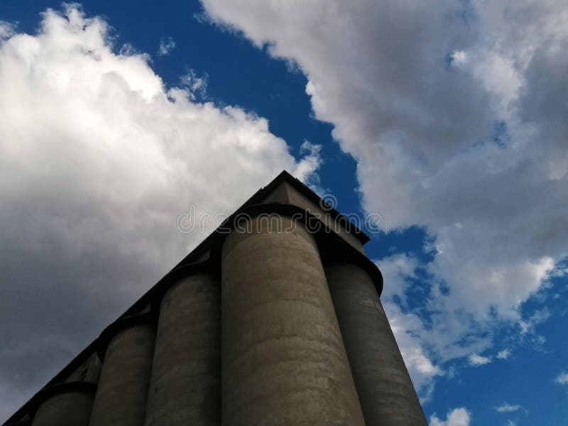 Factory Silos with Clouds in the Background Stock Image - Image of ...