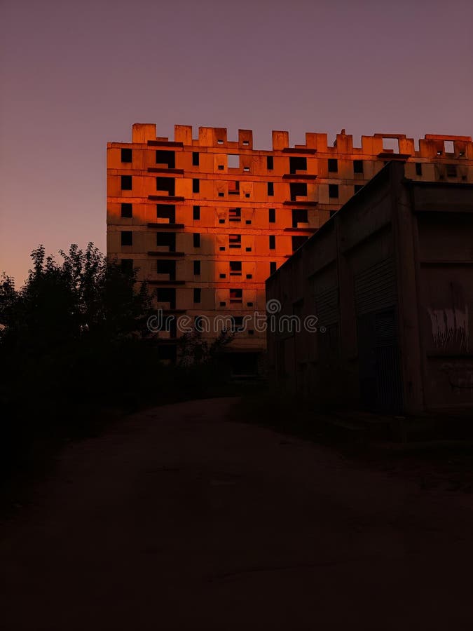 Abandoned High Rise Building Against the Backdrop of a Bright Red ...
