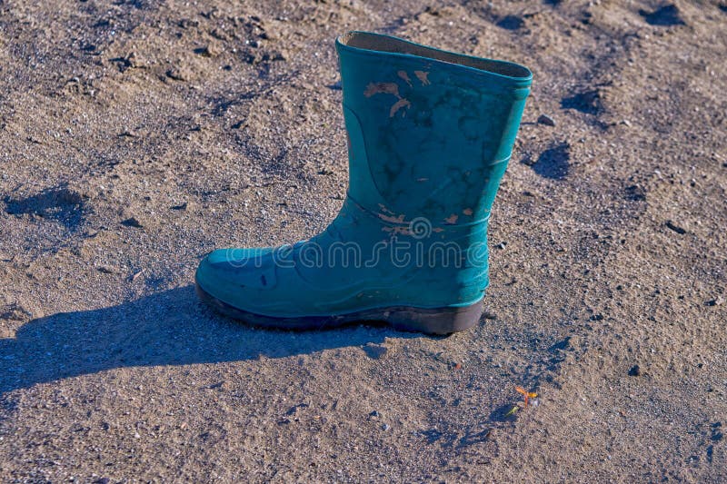 Abandoned Rubber Old Boot of Green Color on the Background of a Sandy ...