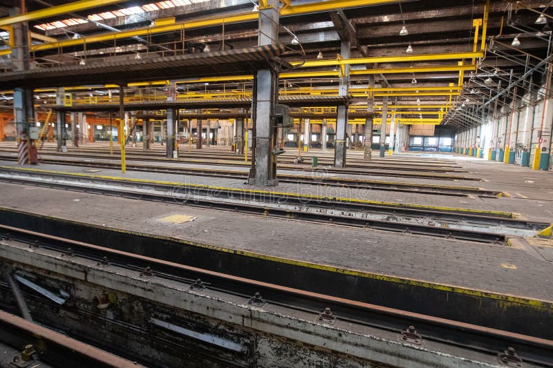 Abandoned Train Repair Facility with Yellow Beams and Rail Tracks Stock ...