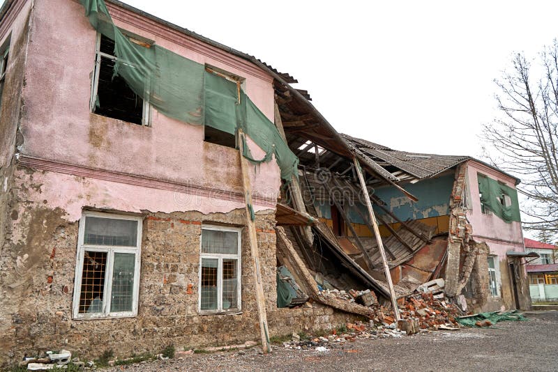 An Abandoned Two-story Building with a Crumbling Roof Stock Photo ...