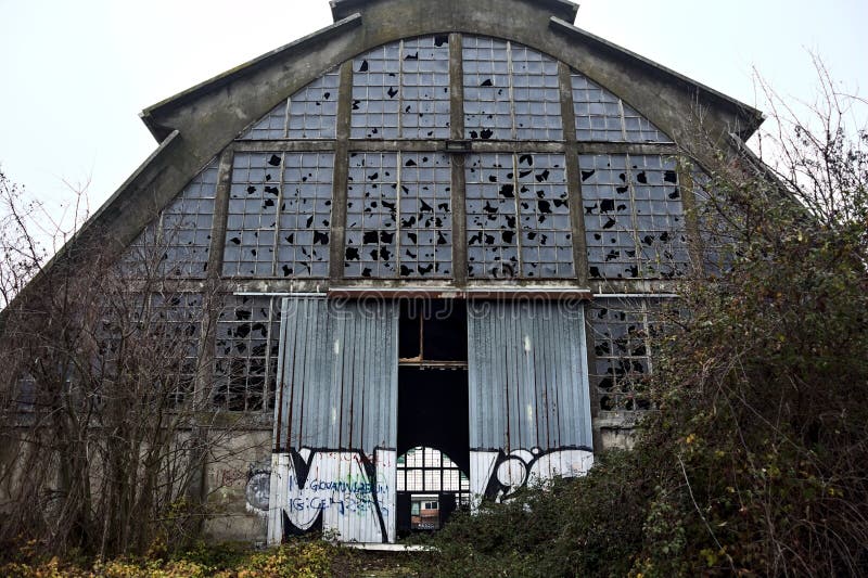 Abandoned Warehouse with Broken Windows in a Park on a Cloudy Day in ...