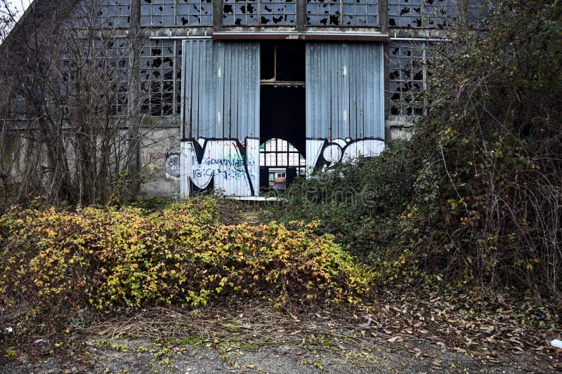 Abandoned Warehouse with Broken Windows in a Park on a Cloudy Day in ...