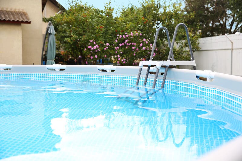 Above Ground Swimming Pool with Handrails and Ladder in Backyard Stock ...
