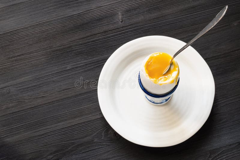 Soft-boiled Egg with Spoon on White Plate on Dark Stock Image - Image ...