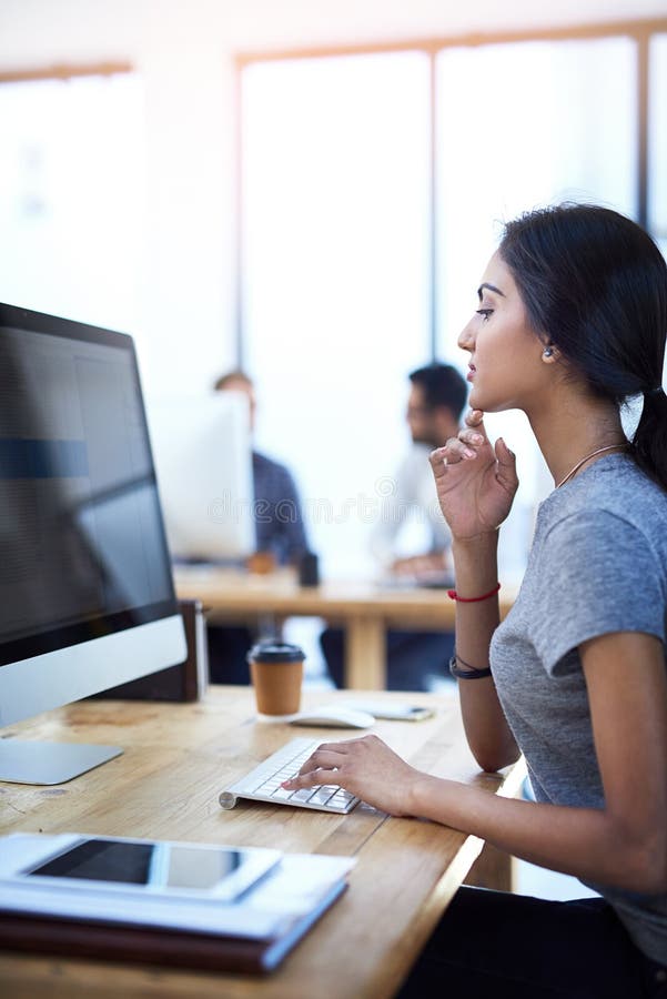 Absorbed in Her Work Tasks. a Focused Young Businesswoman Using a ...