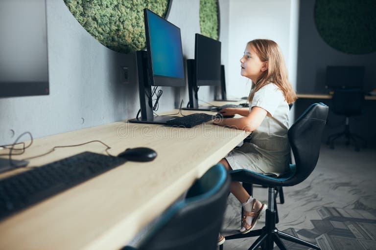 Absorbed Schoolgirl Learning To Use Technology in Classroom at Primary School. Child Using ...