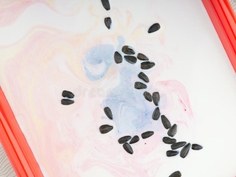 Abstract Background of White Liquid and Small Black Objects Floating in ...