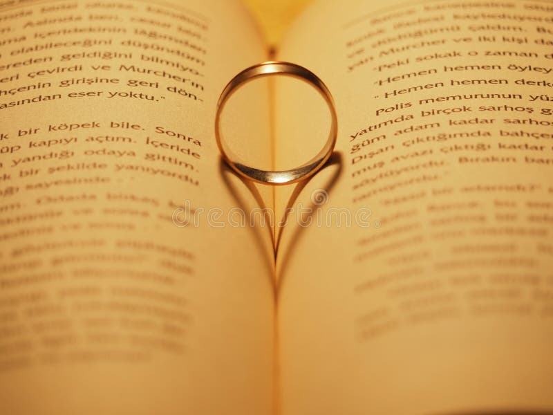Abstract Heart Shape Shadow of Wedding Ring on a Book. Stock Image ...