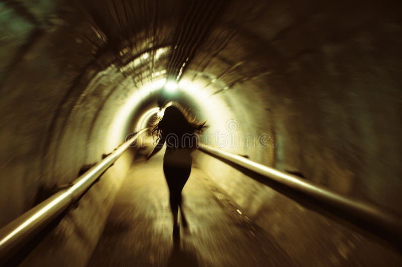 Abstract Image of a Young Woman Walking in a Tunnel with Motion Blur ...