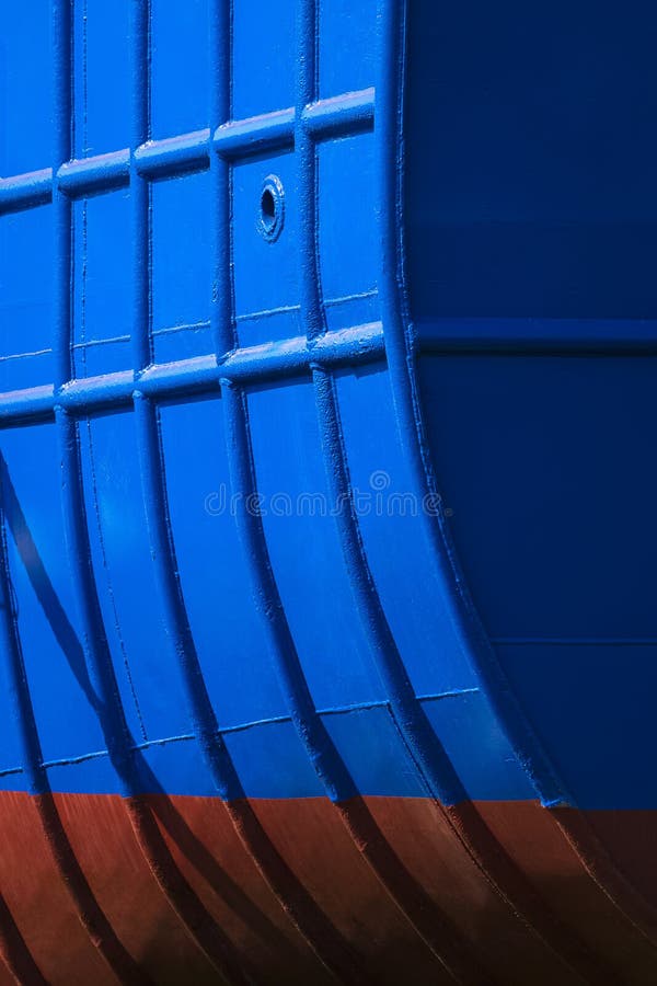 Blue and Red Stern Hull of Large Vessel with Light and Shadow on ...