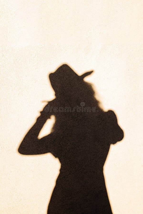 Abstract Shadow of a Woman Wearing Hat on the Wall in Sunset Light ...