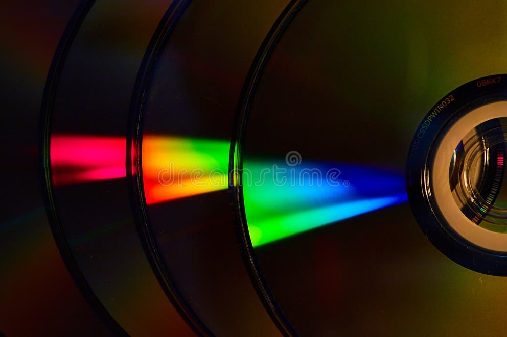 Abstract Stack of Four Dark Silvery CDs with Reflective Rainbow Bursts ...