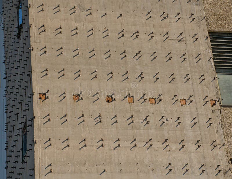 Abstract View of a Concrete Wall with a Grid of Metallic Brackets ...