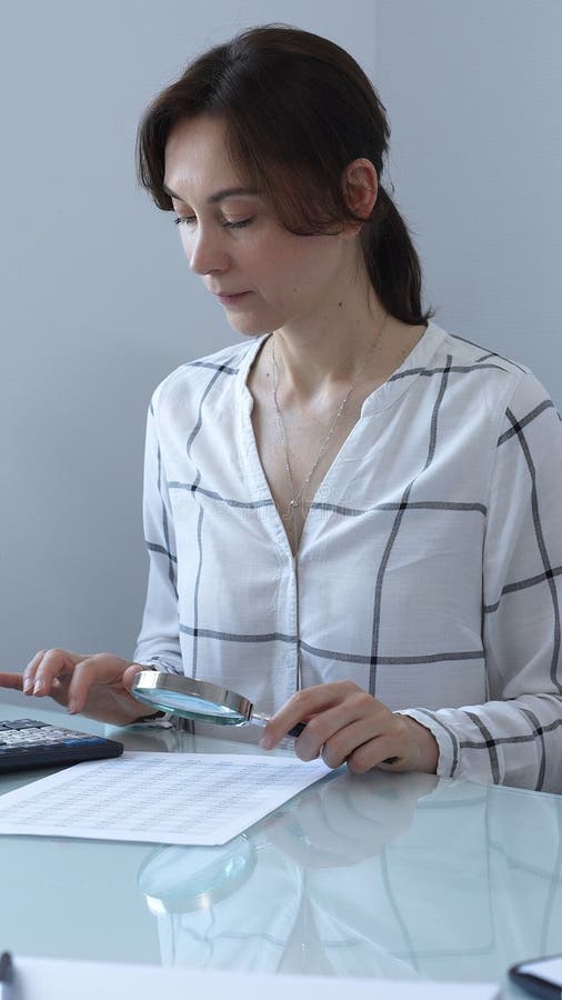 Accountant Carefully Reviewing Financial Documents, Magnifying Details ...