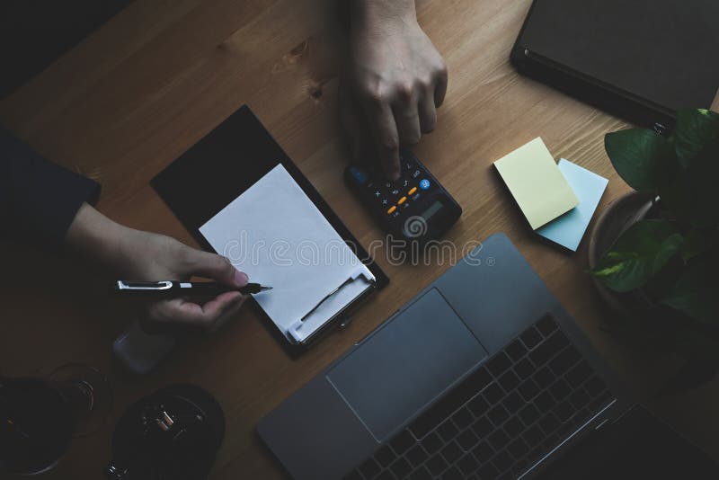 Accountant Making Note on Notebook and Using Calculator. Stock Photo ...