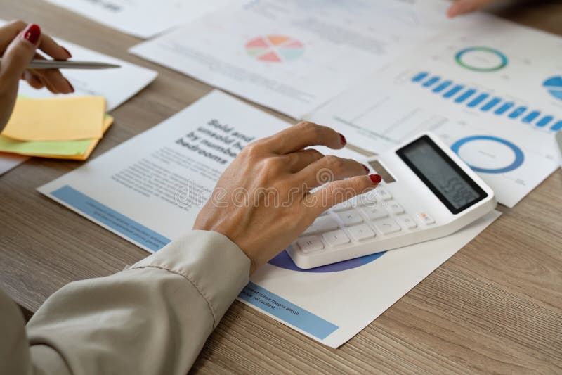 Accountant Analyzing Financial Data with Calculator and Reports on a ...