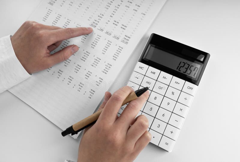 Accountant Using a Calculator and Points Her Finger at the Numbers in ...