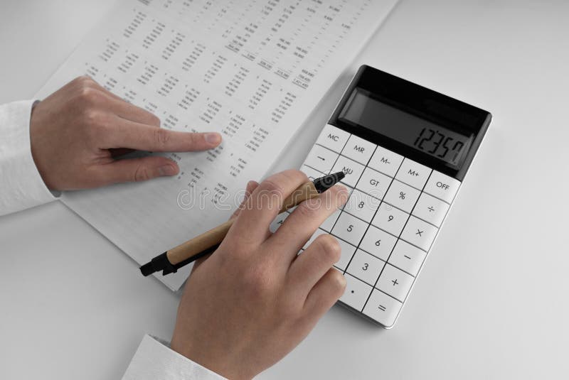 Accountant Using a Calculator and Points Her Finger at the Numbers in ...