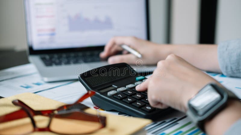 Accountant Working on Desk Using Calculator for Calculate Finance ... Accountant Working on Desk Using Calculator for Calculate Finance ...