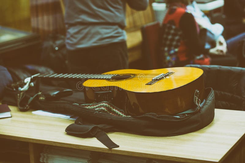 Acoustic Guitar Lying on a Wooden Table Lit by a Beam of Light. Guitar ...