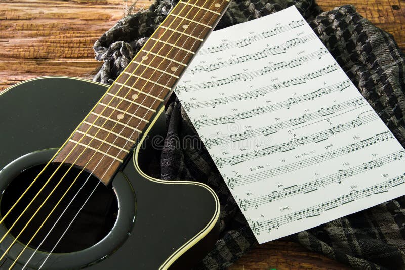 Acoustic Guitar and Sheet Musical Notes on the Table. Stock Image ...