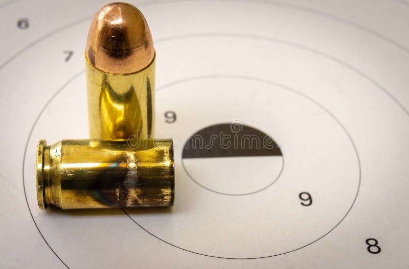 A 45 Acp Bullet with a Paper Target in the Background Stock Photo ...