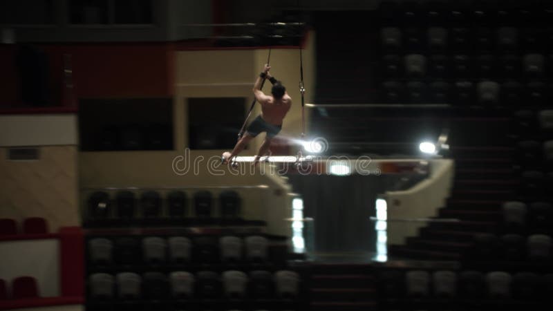 An Acrobatic Man Rotating Upside Down on the Flying Bar at Circus Stock ...