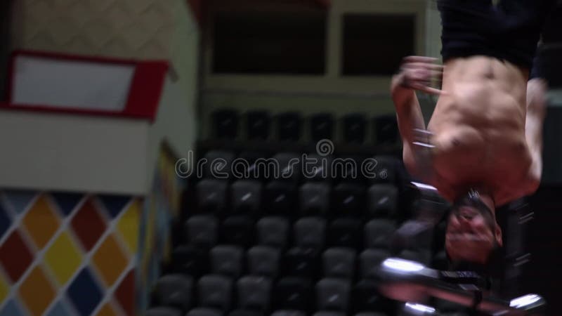 An Acrobatic Man Rotating Upside Down on the Flying Bar at Circus Stock ...