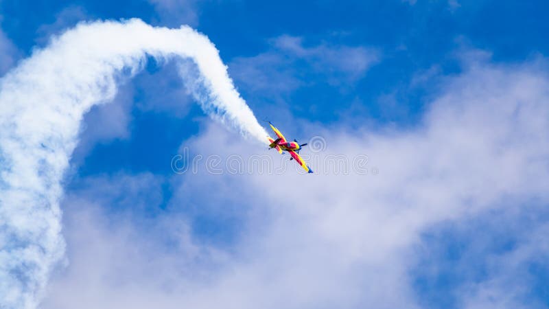 An Acrobatic Plane, Flying in the Blue Sky with White Clouds, Doing ...