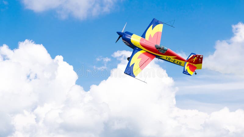 An Acrobatic Plane, Flying in the Blue Sky with White Clouds, Doing ...