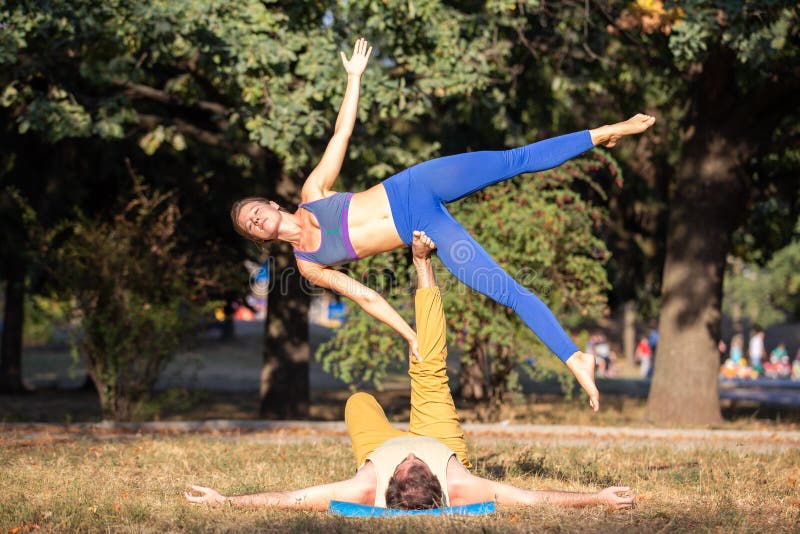 Acroyoga Couple Doing Side Star Pose in the Park Stock Photo - Image of ...