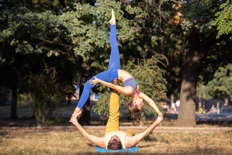Acroyoga Couple Doing Side Star Pose in the Park Stock Photo - Image of ...