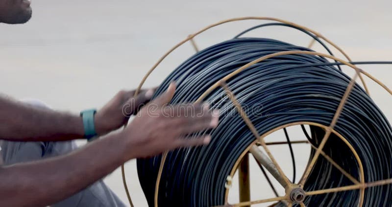 Action of a Worker is Rolling the Electrical Wire Cable into the Reel ...