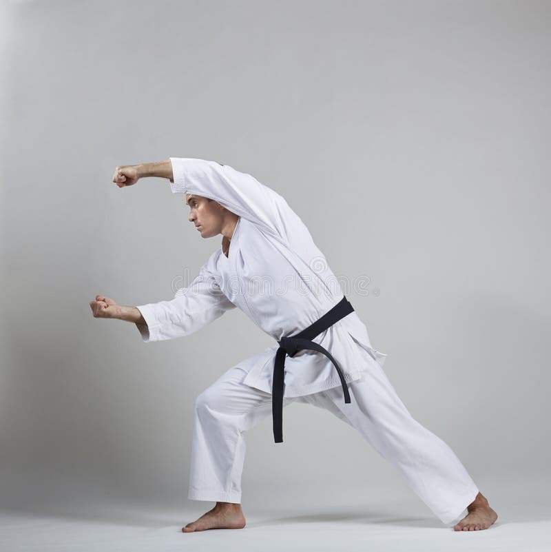 Active Adult Athlete Doing Formal Karate Exercises on Gray Background ...