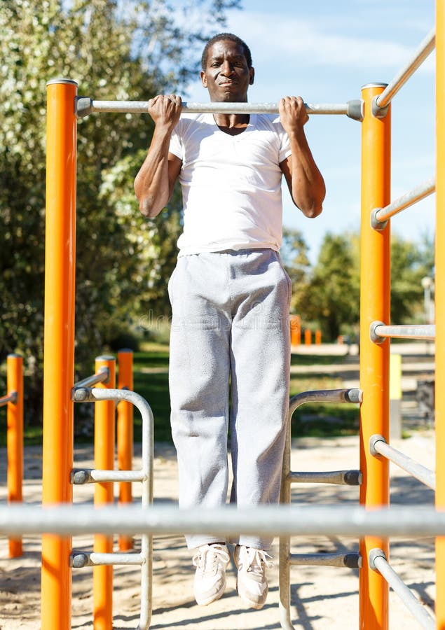 Active African American Man Doing Workout at Pull-up Bar in Park Stock ...
