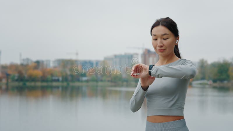 Active Asian Female Athlete Using a Smartwatch before Jogging Outside ...