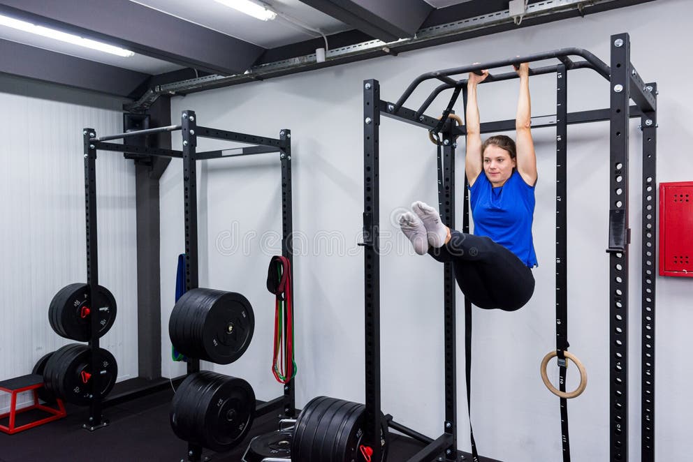 Active Brunette Having Fun on Pullup Rig Doing Leg-raises. Stock Image ...
