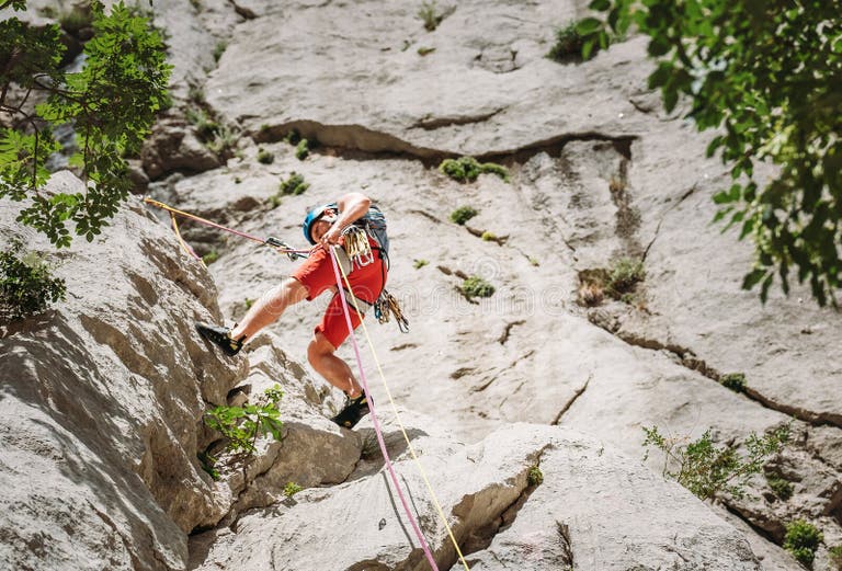 Active Climber Middle Age Man in Protective Helmet while Abseiling from ...