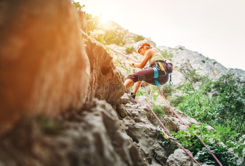 Active Climber Woman in Protective Helmet Abseiling from Cliff Rock ...