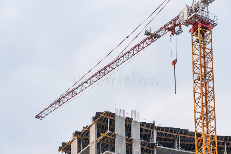 An Active Construction Site with a Yellow Crane, Hoisting Materials for ...