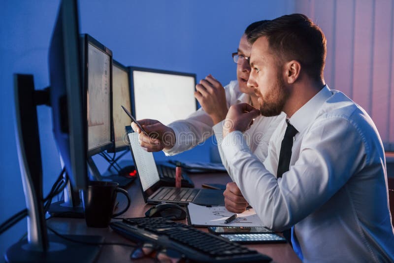 Active Conversation. Two Stock Traders Working in the Office with ...