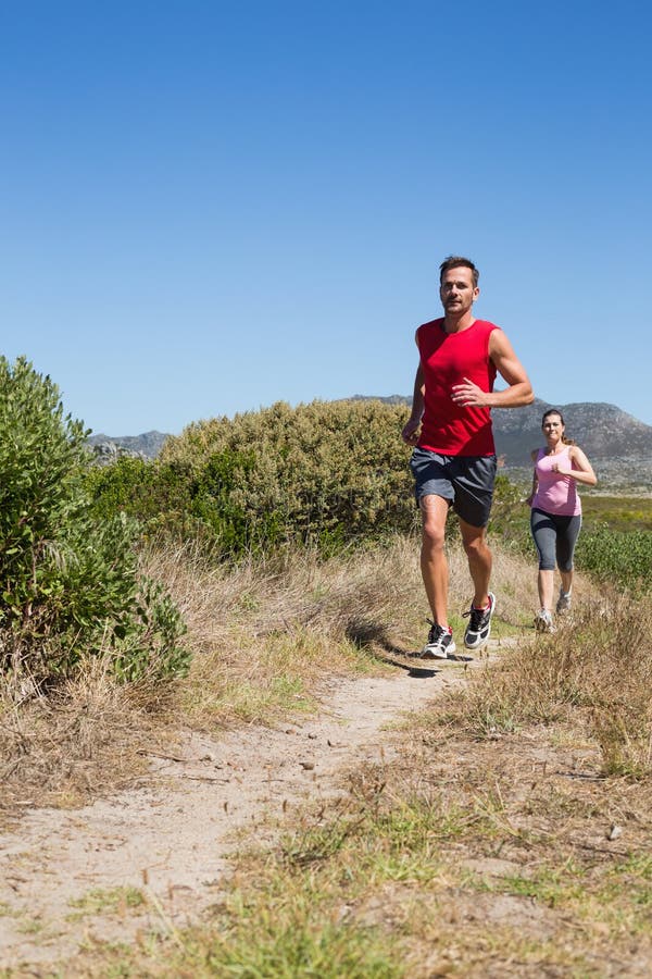 Active Couple Jogging on Country Terrain Stock Photo - Image of ...