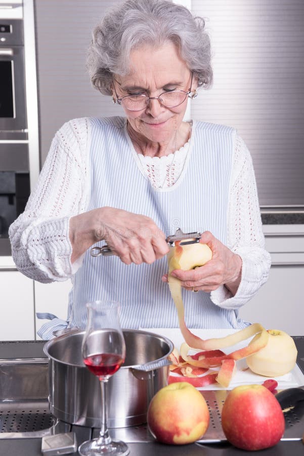 Active Female Senior Peeling Apple in the Kitchen Stock Photo - Image ...