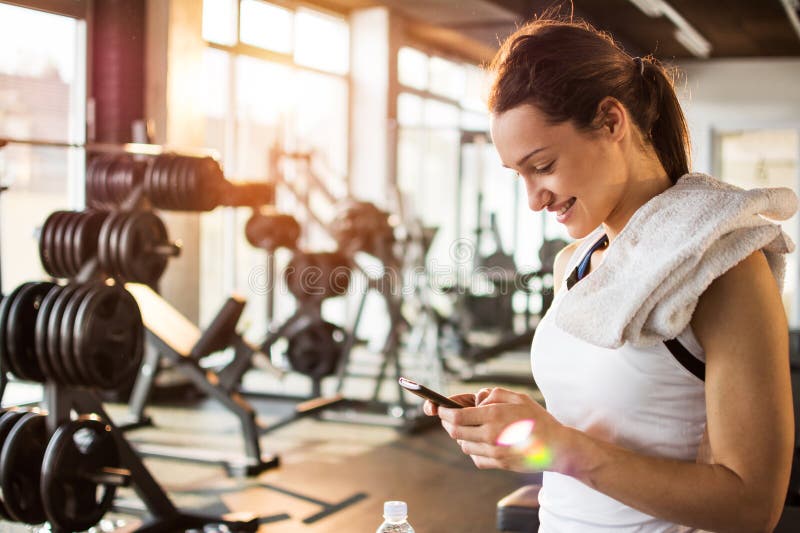Active Girl Using Smartphone in Fitness Gym. Stock Photo - Image of ...